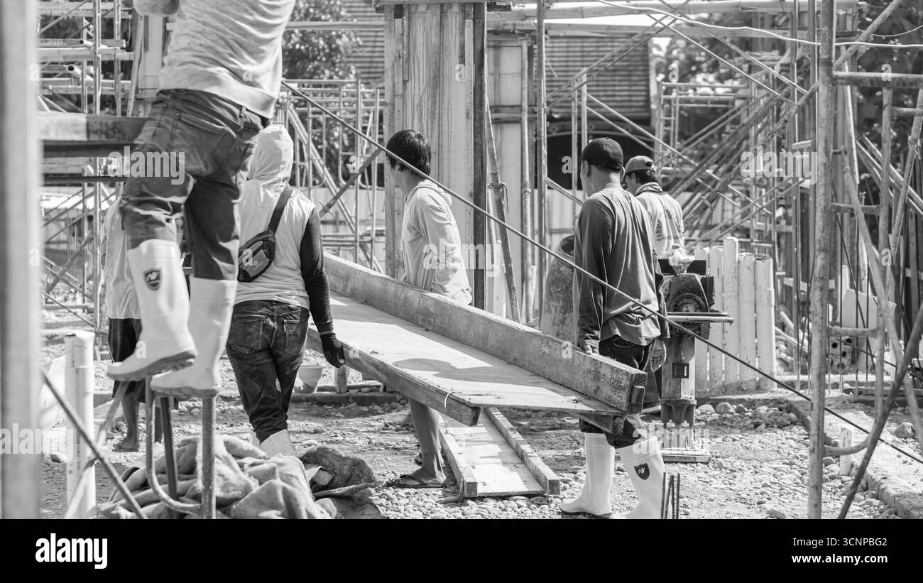 Construction workers dismantle column formwork after concrete curing ...