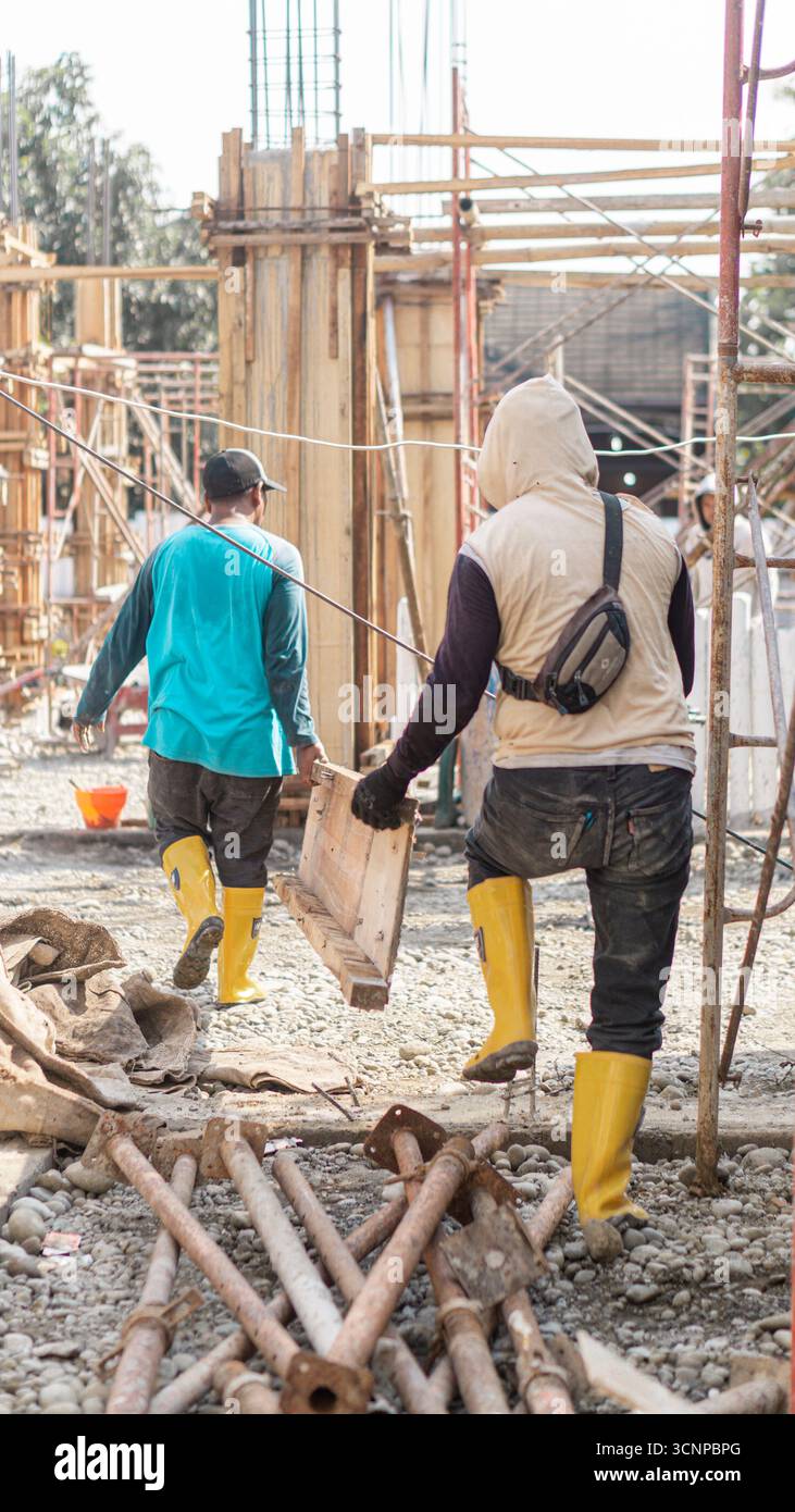 Construction workers dismantle column formwork after concrete curing ...