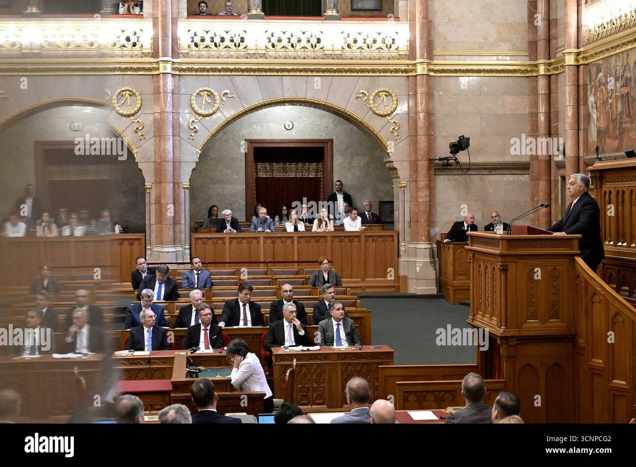 Hungarian Prime Minister Viktor Orban, right, delivers a pre-agenda address during the first ...