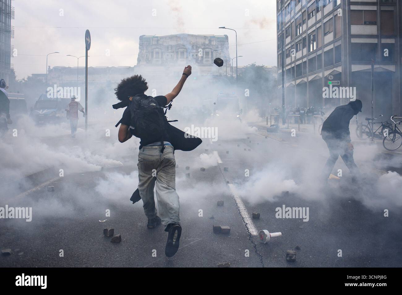 Protesters throw rocks during clashes with riot police as they ...