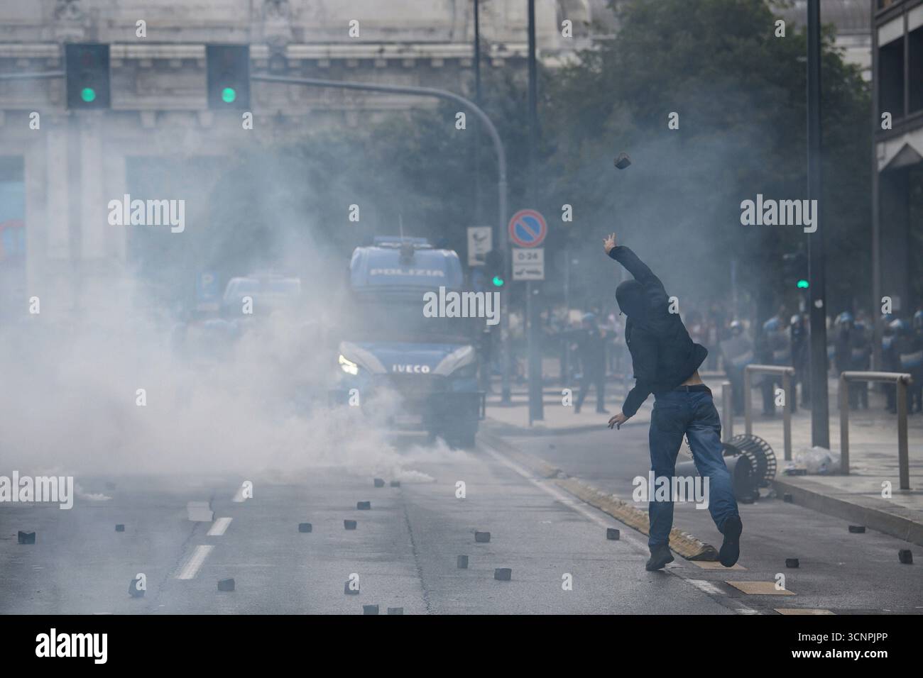 Protesters throw rocks during clashes with riot police as they ...
