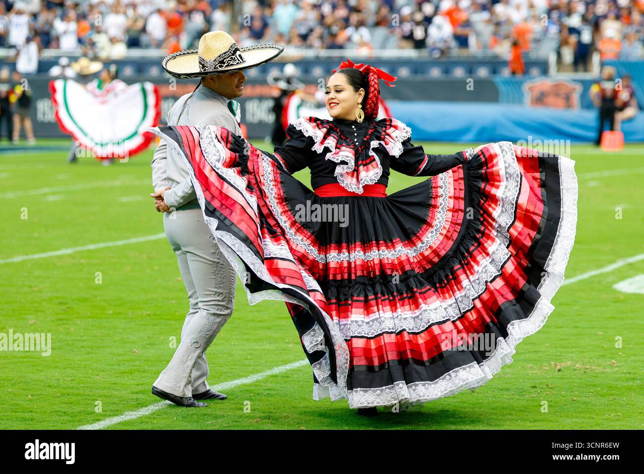 Folklorico dancers perform at halftime of an NFL football game between ...