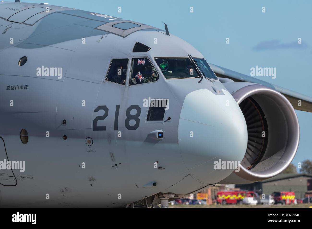 A pilot waves a Union Jack Flag as a Kawasaki C-2 transporter leaves ...