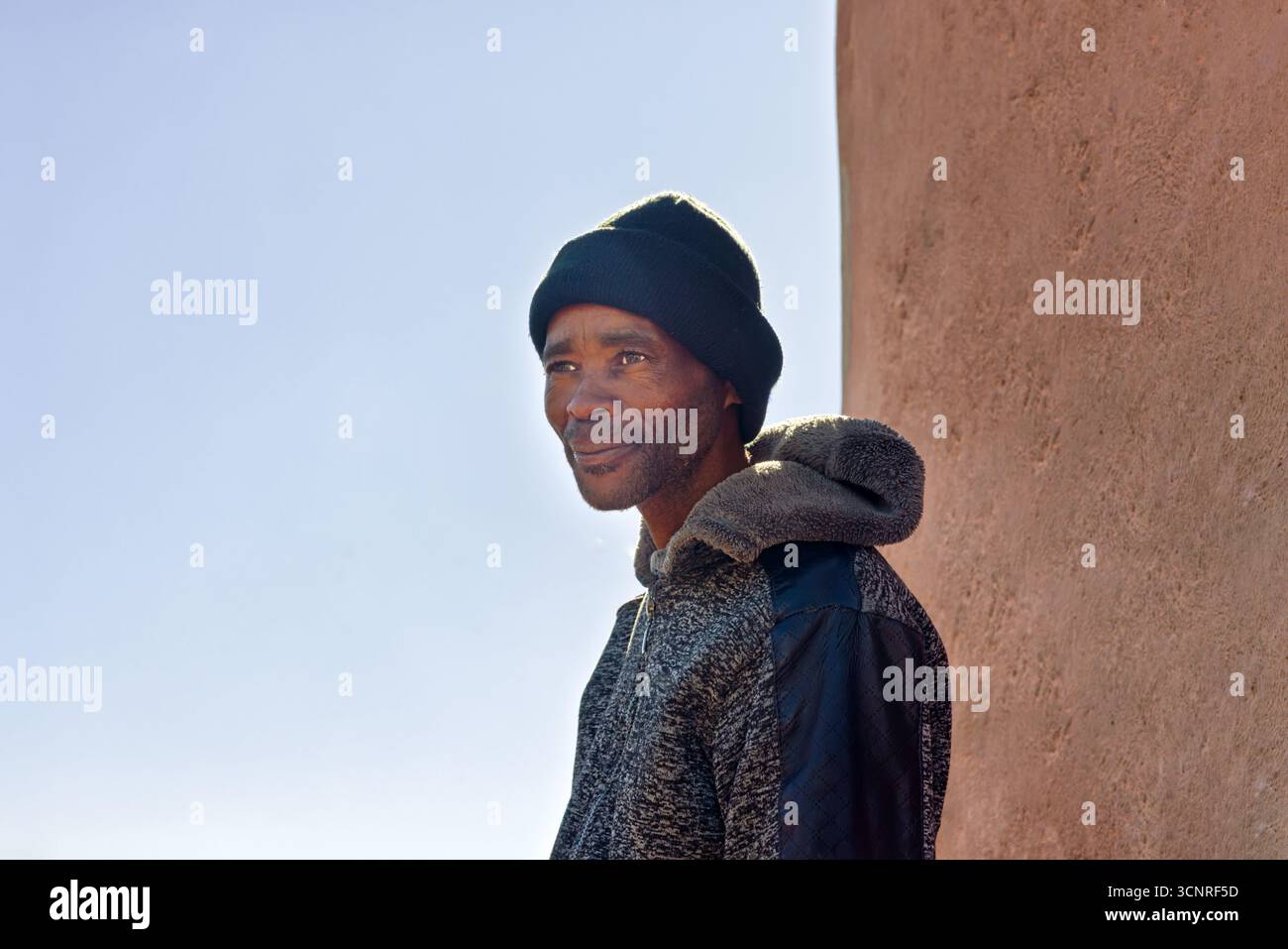 africa village, single african man with a hoodie and beanie, in the ...