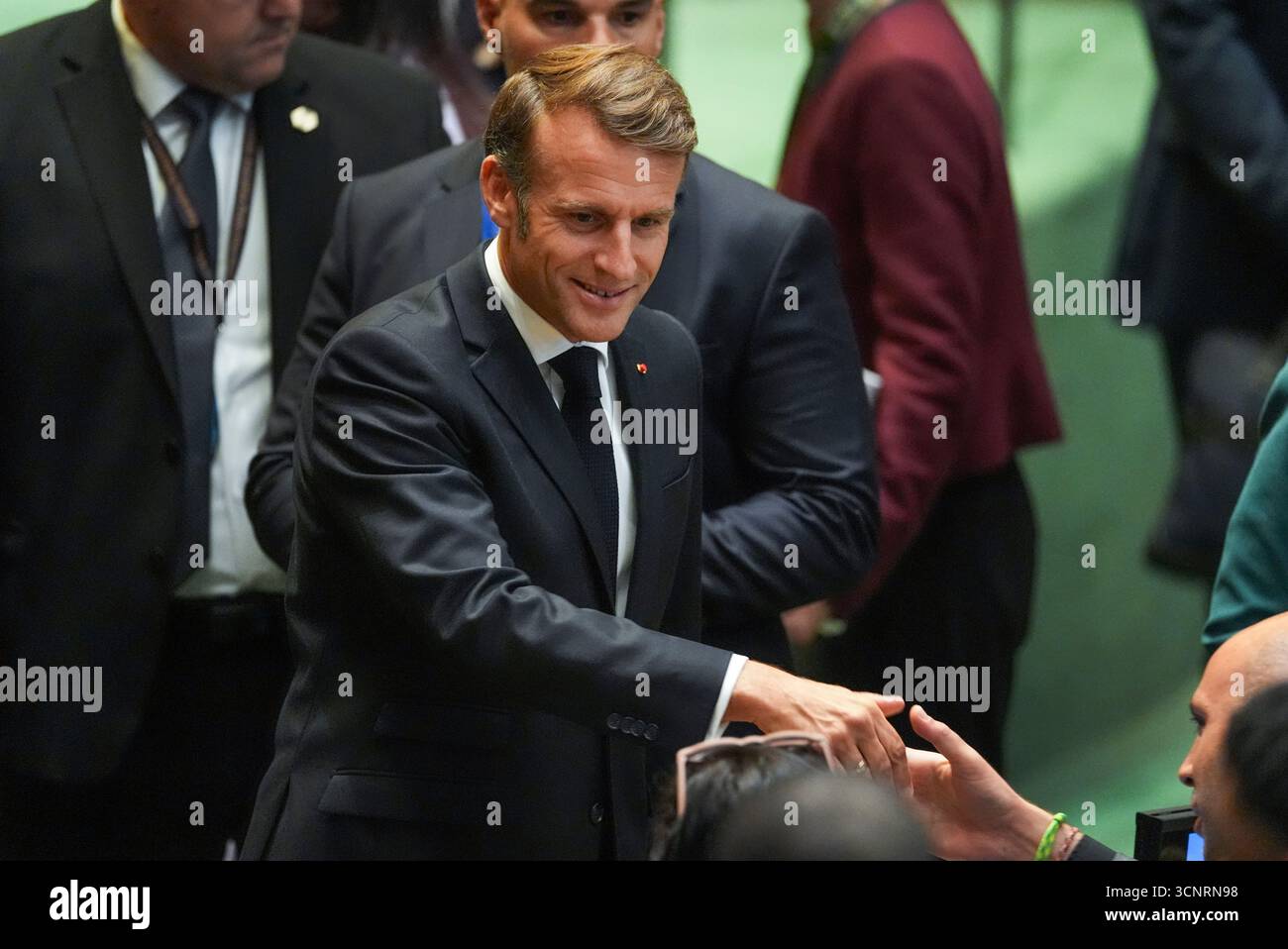 French President Emmanuel Macron greets delegates upon arriving inside ...
