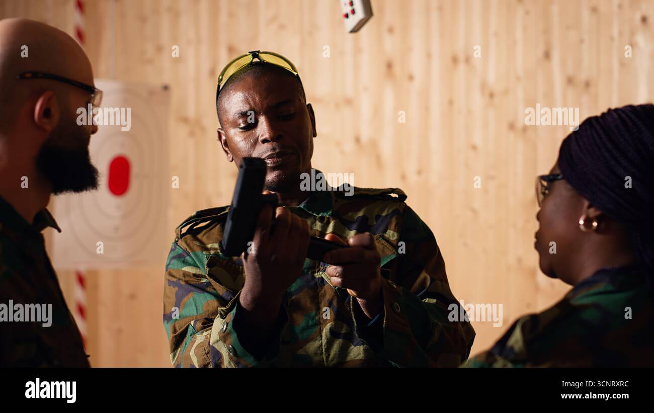 Army commander talking with recruits in shooting gallery, showing them ...