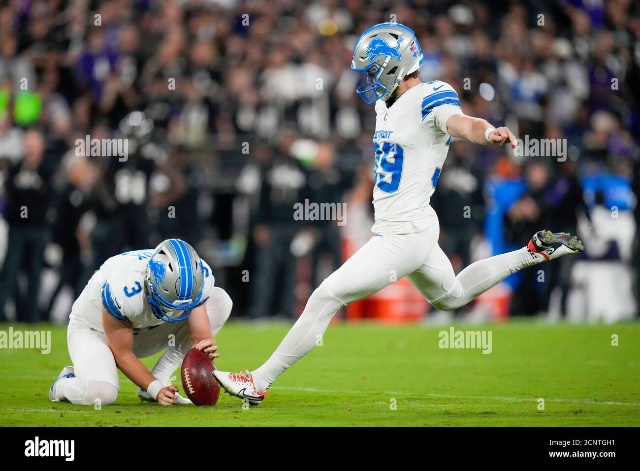 Detroit Lions kicker Jake Bates, right, with Jack Fox holding, kicks an ...