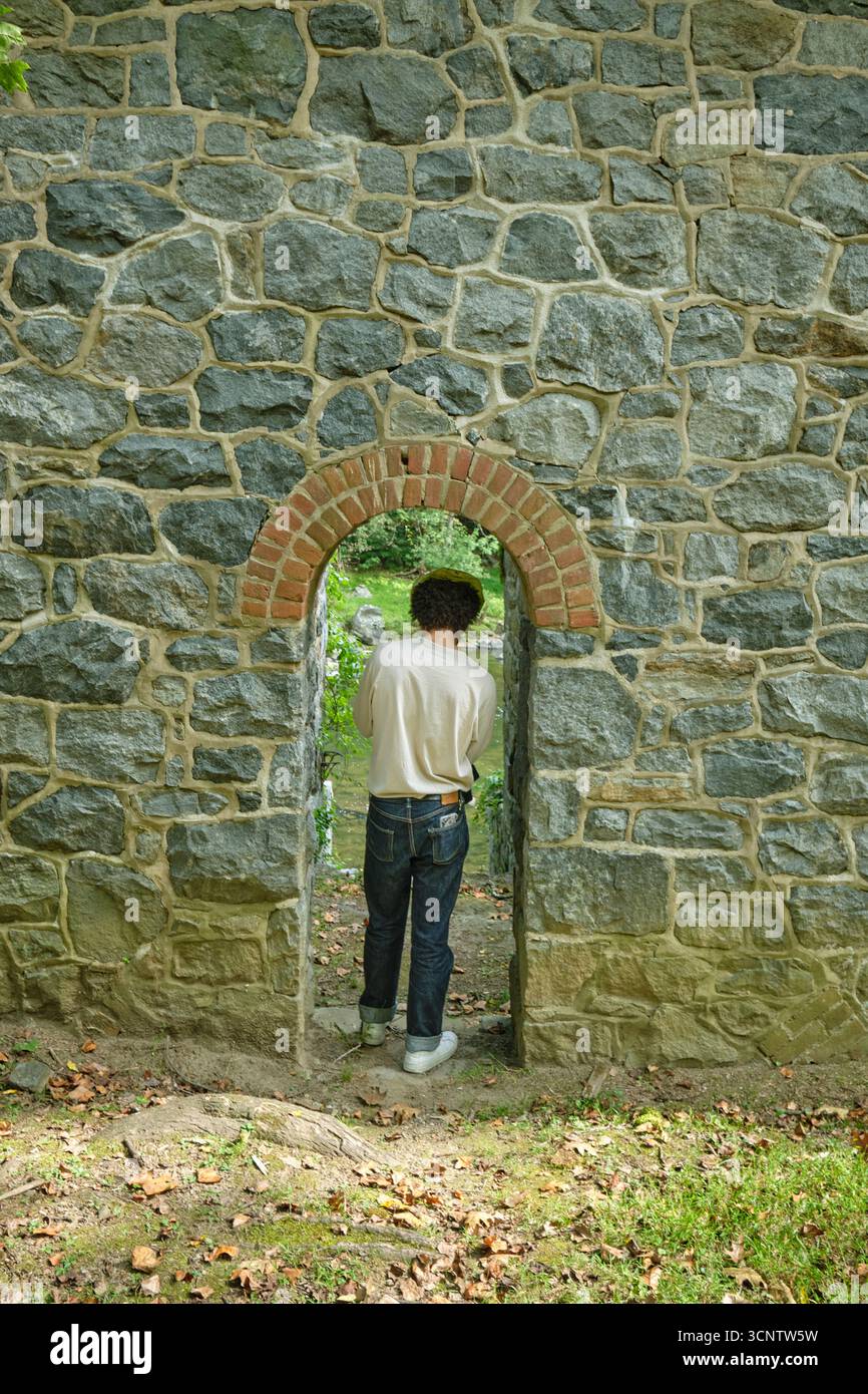 A visitor explores the ruins of a historic powder mill at Hagley Museum ...