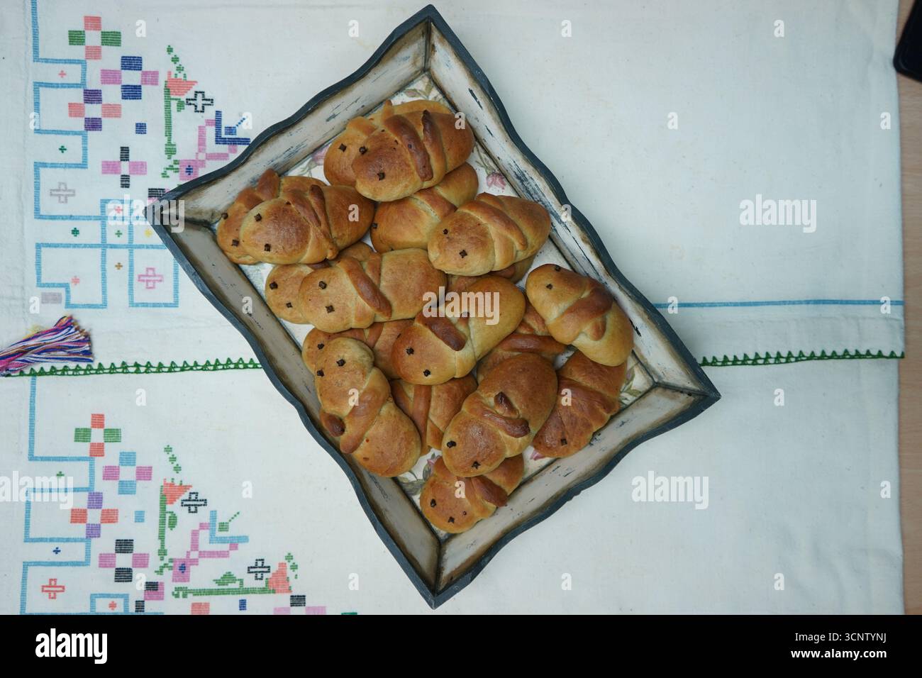 A top-down view of a tray with "Lazarakia" bread rolls on a Cretan ...
