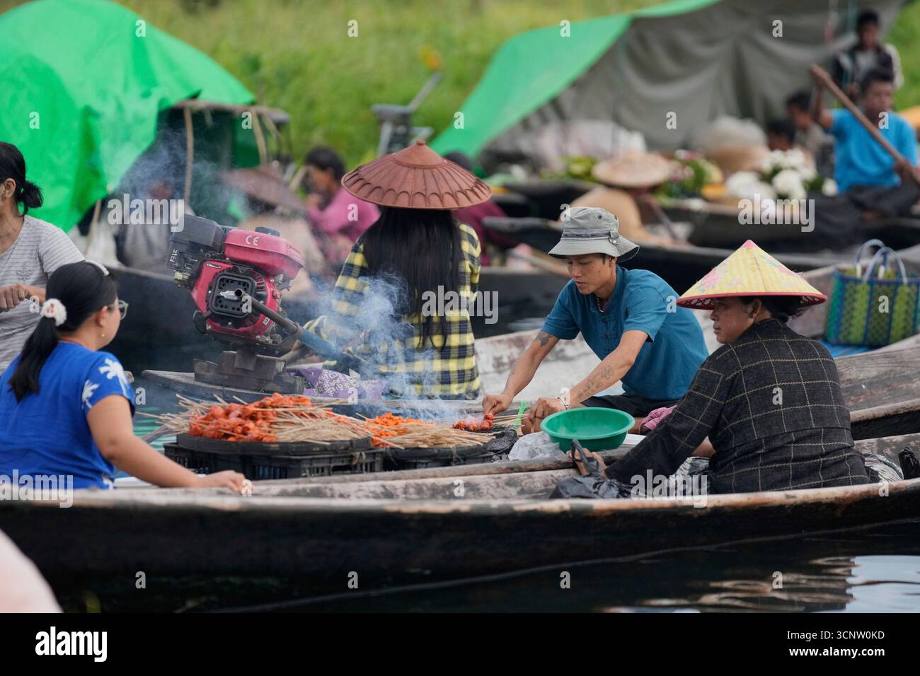 A vendor prepares food for customers at a local floating bazaar Tuesday ...