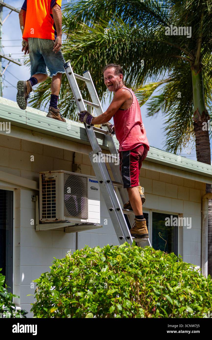 man standing on ladder laughing to roof climbing down ladder one man ...