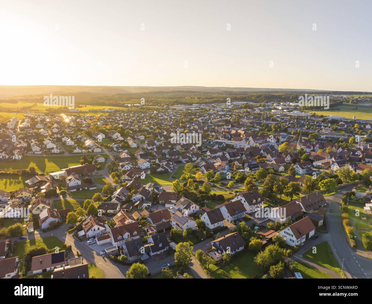 Aerial view of a village at sunset with densely built-up houses and ...