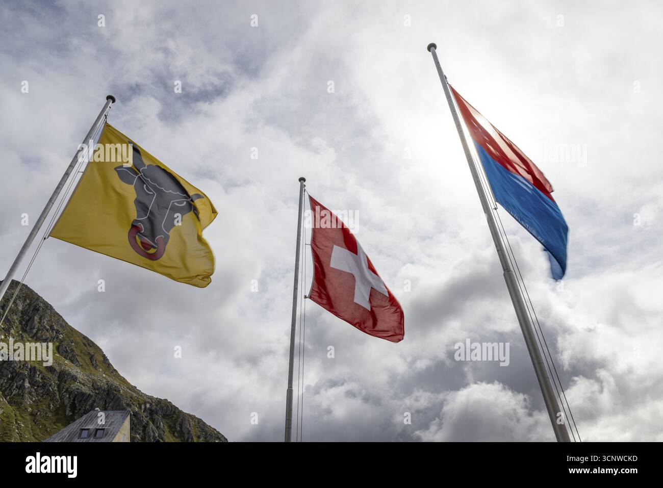 Flags of the cantons of Uri and Ticino and the Swiss flag waving in the ...