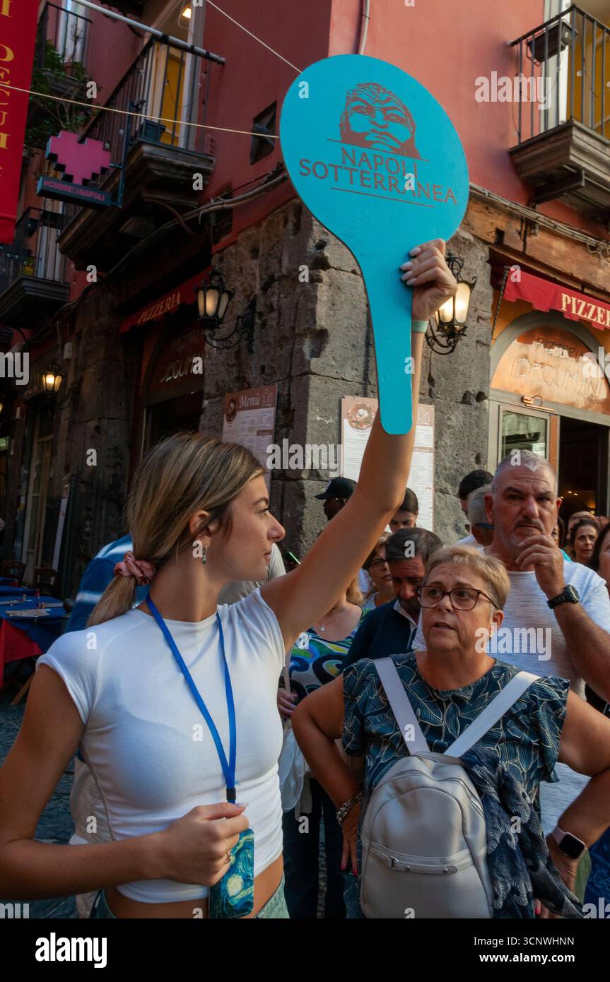 A female tour guide of the Naples Underground (Napoli Sotterranea) with ...