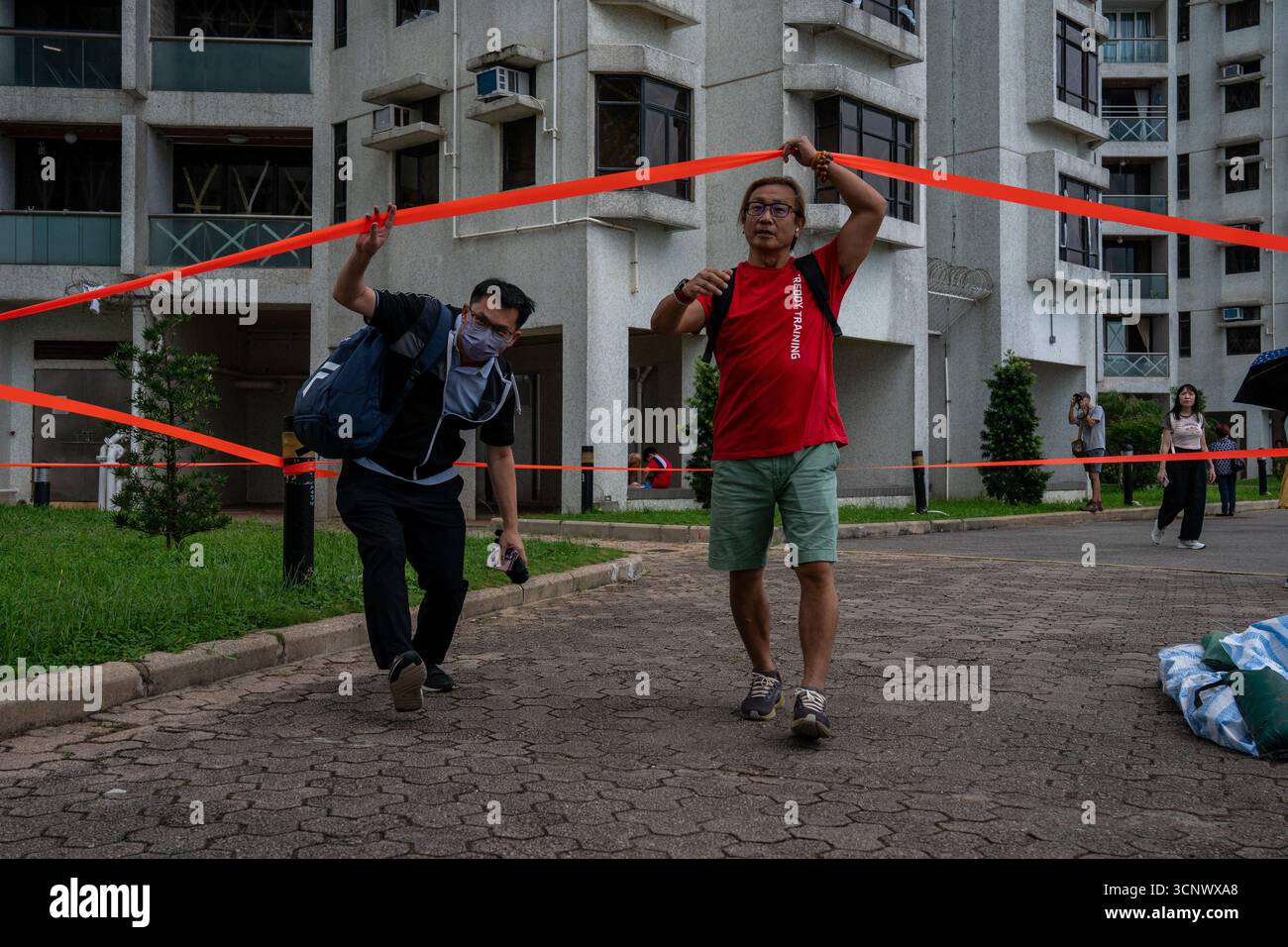 People walking pass warning tapes at Heng Fa Chuen as Typhoon Ragasa ...
