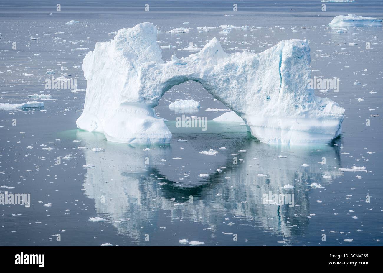 Majestic iceberg arch in the serene waters of Ilulissat, Greenland ...