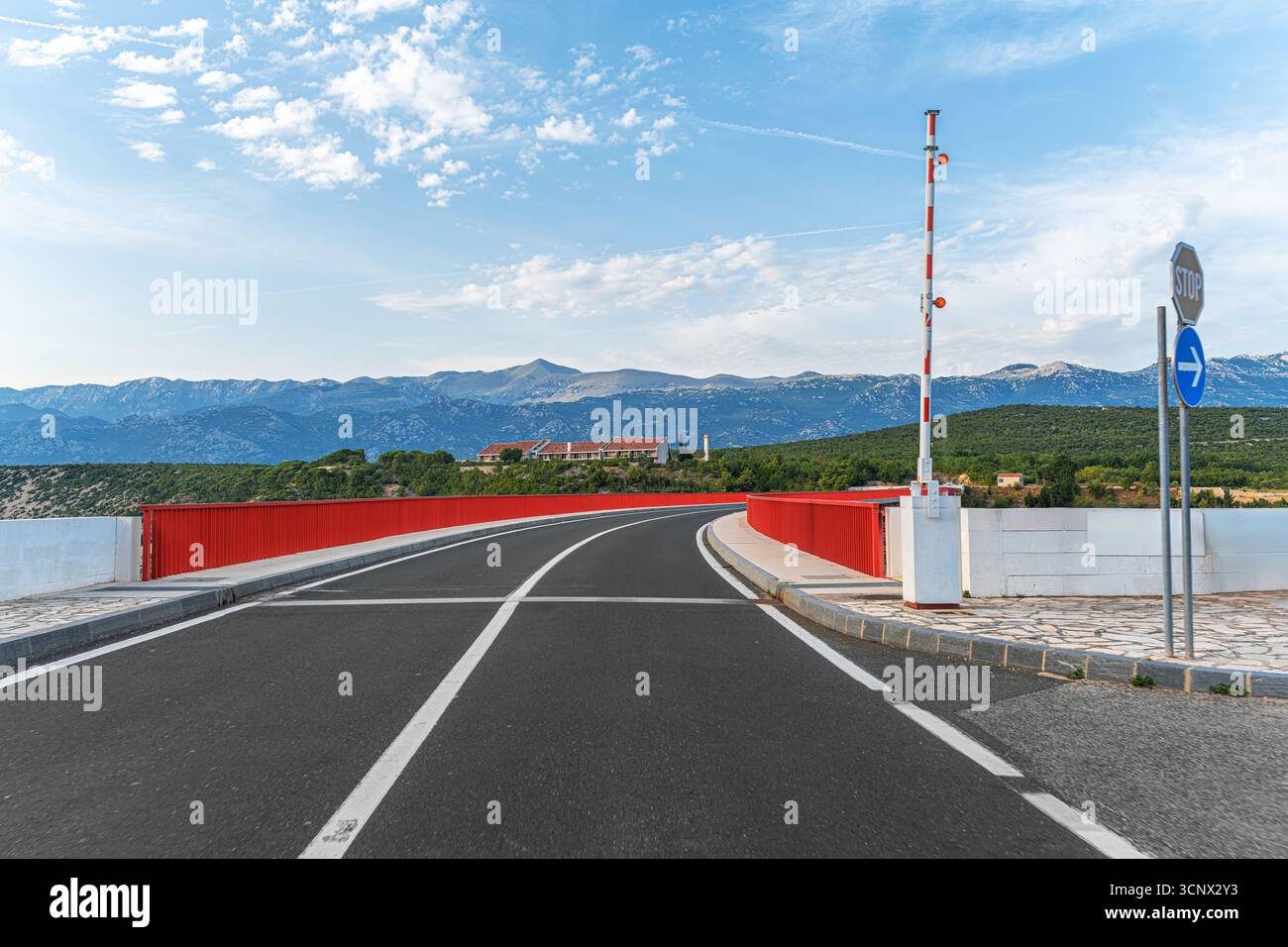 Curved asphalt bridge with red railings and a stop sign Stock Photo - Alamy
