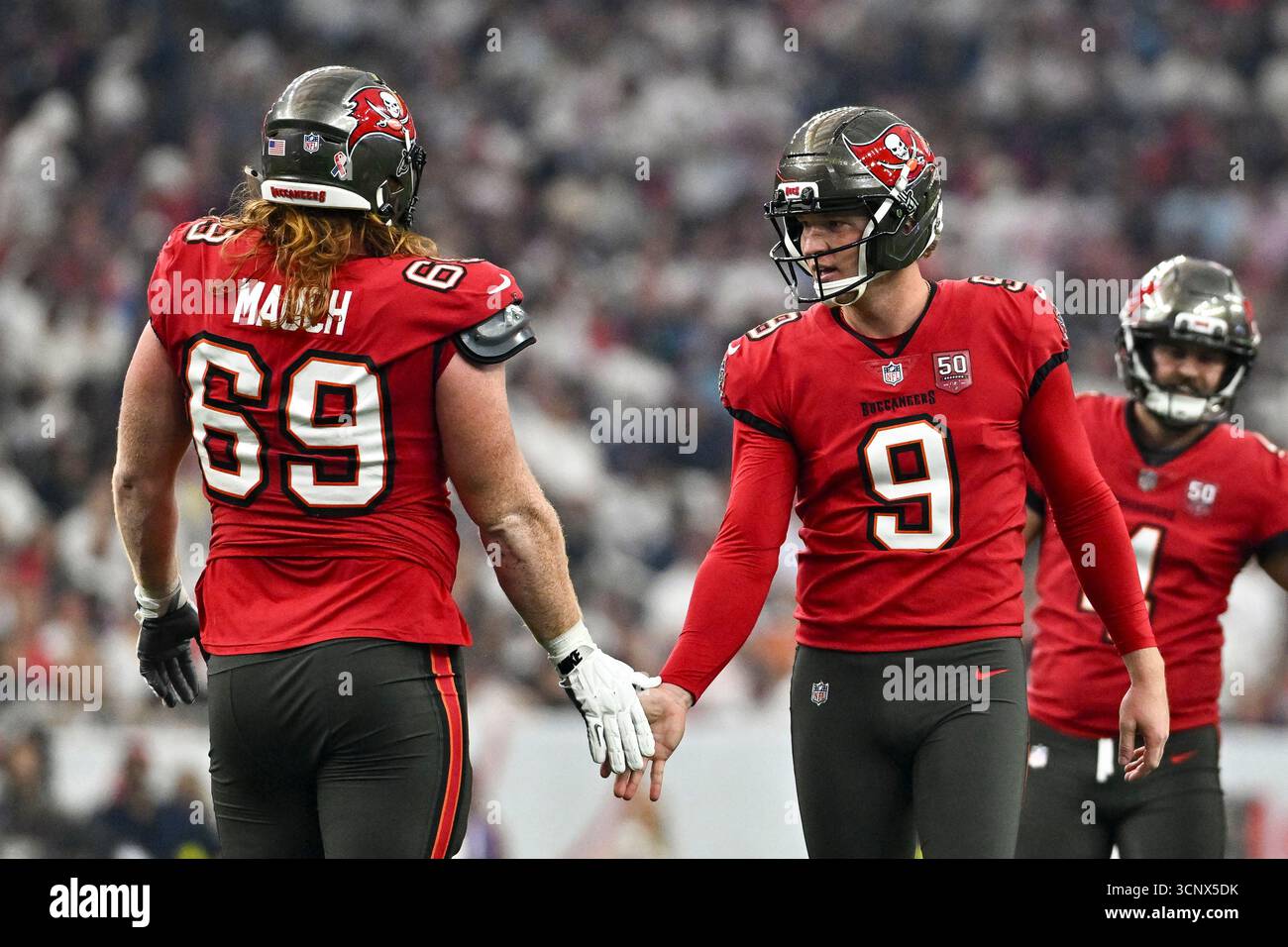 Tampa Bay Buccaneers punter Riley Dixon (9) and guard Cody Mauch (69) high five during the first ...