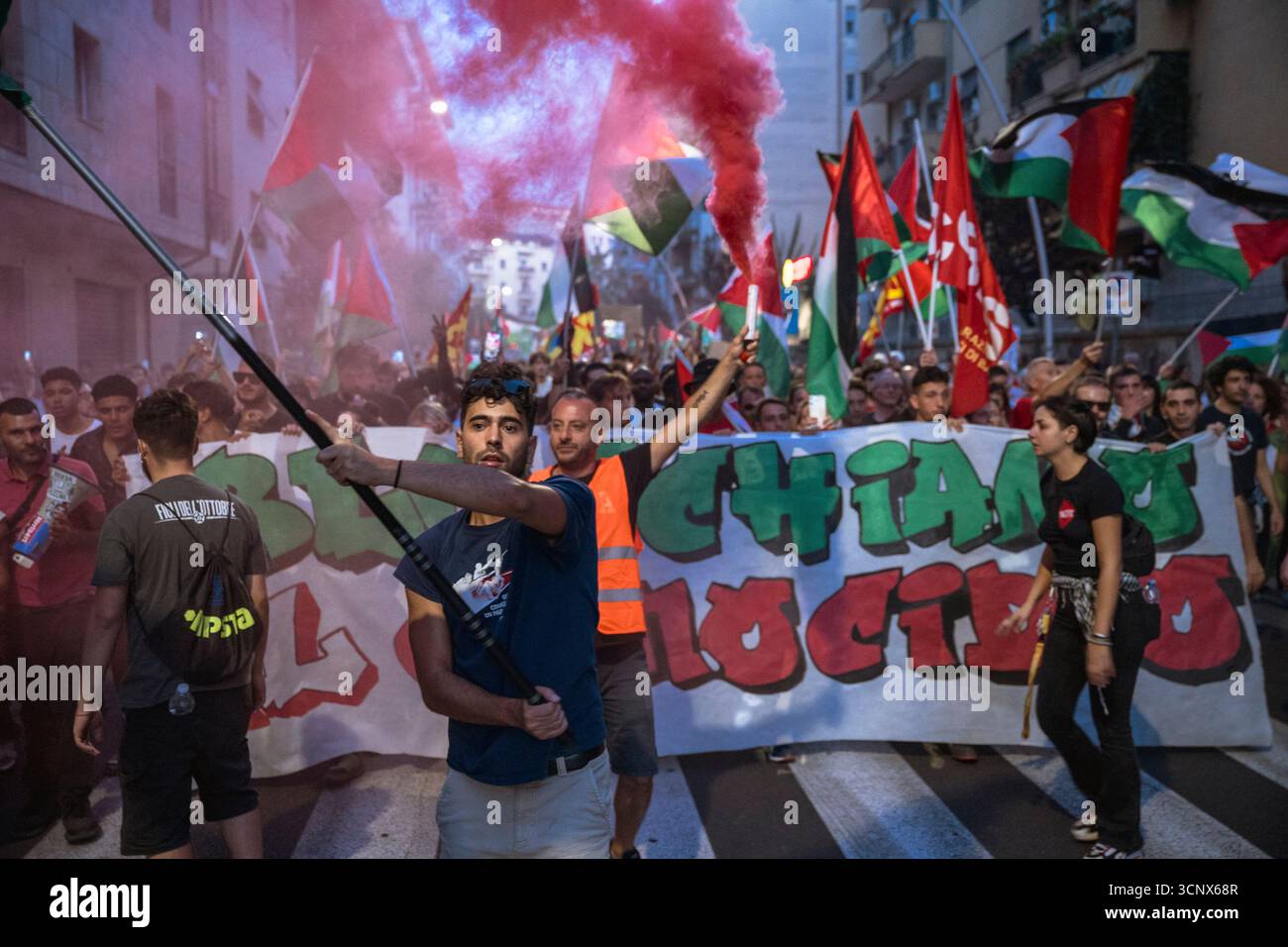 Protesters hold a banner and flags on the street during the rally ...