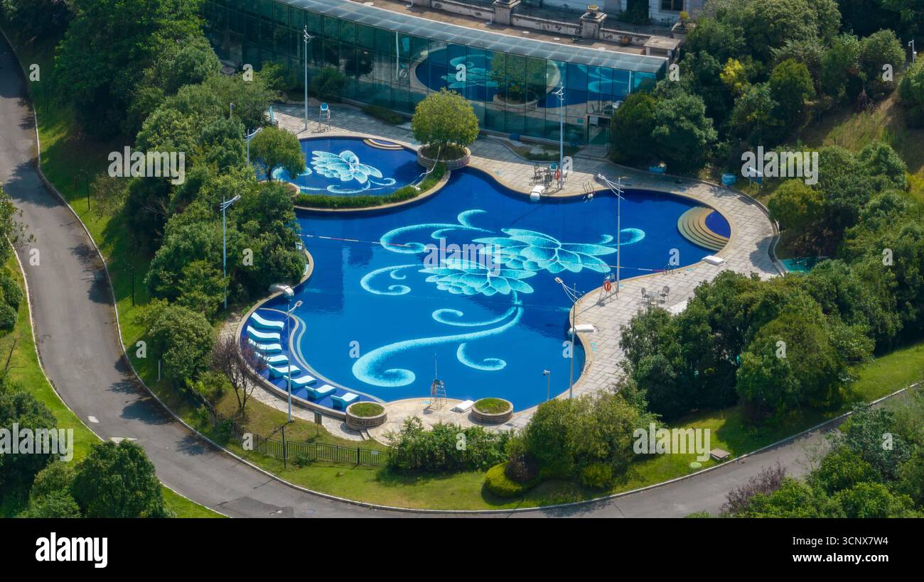 Aerial view of a uniquely shaped, blue swimming pool adorned with ...