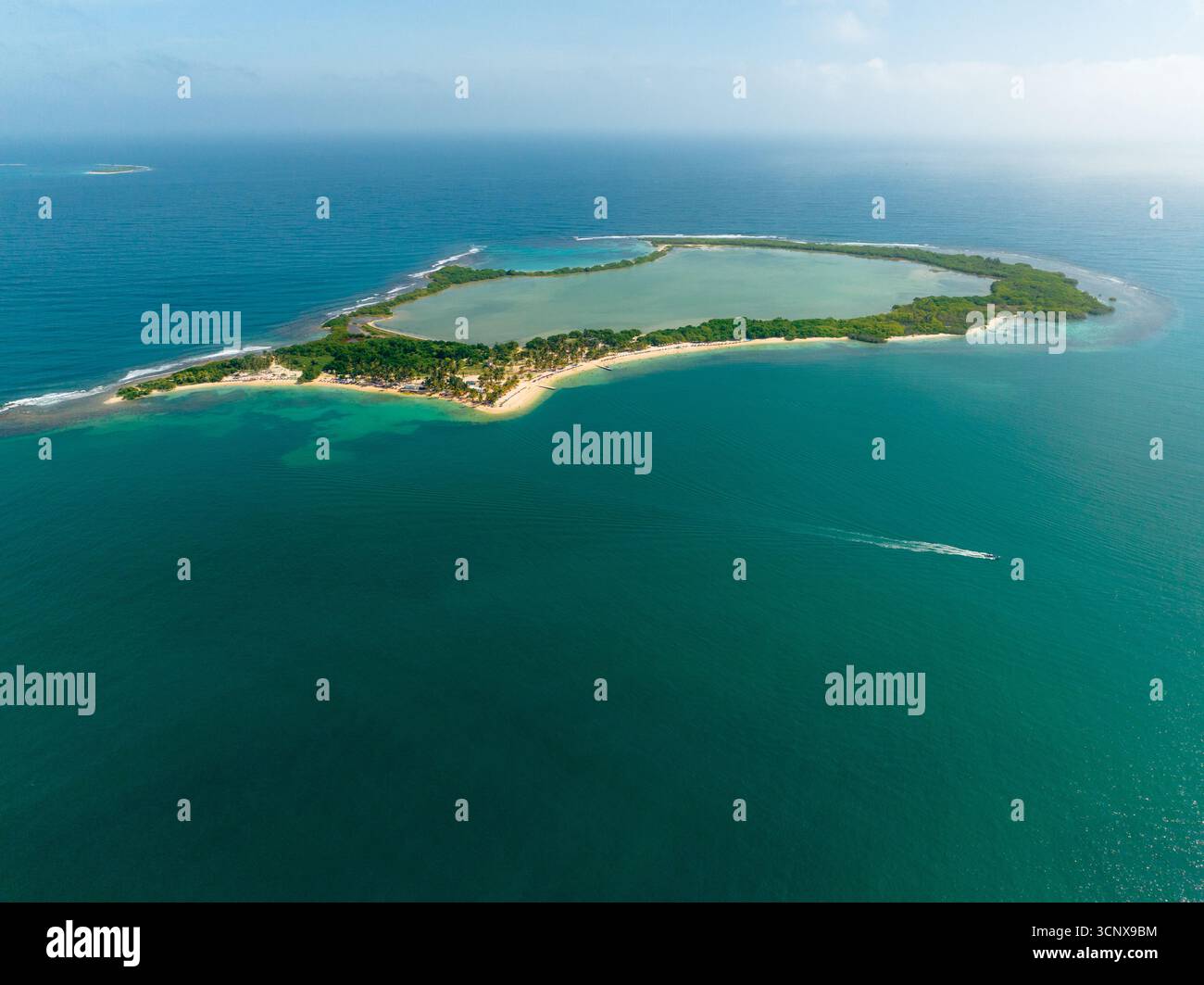 Aerial view of a serene island embraces a tranquil lagoon, fringed by ...