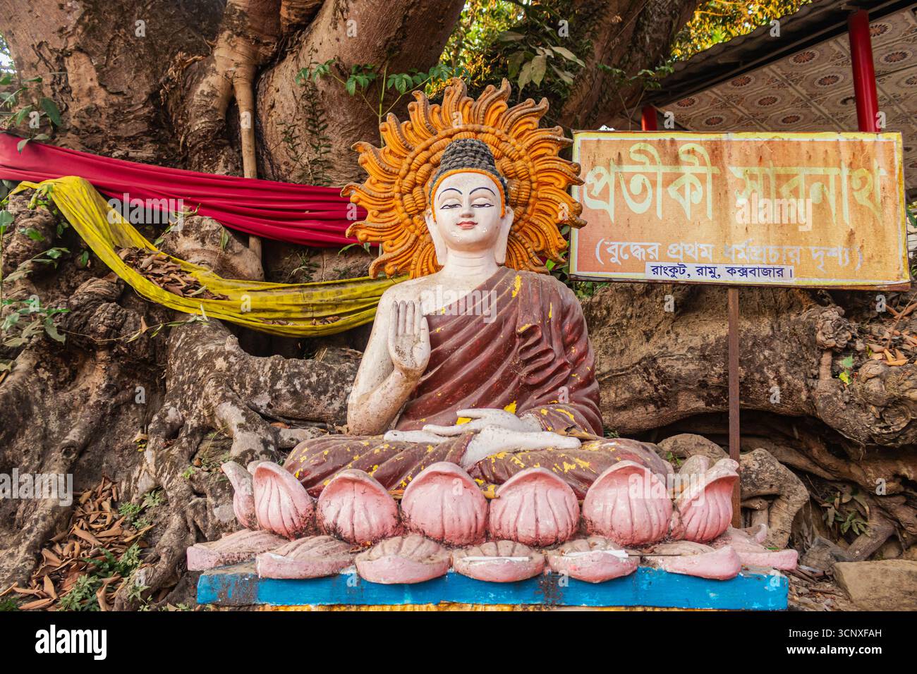 Close-up statue of Buddha with orange halo seated on lotus pedestal ...