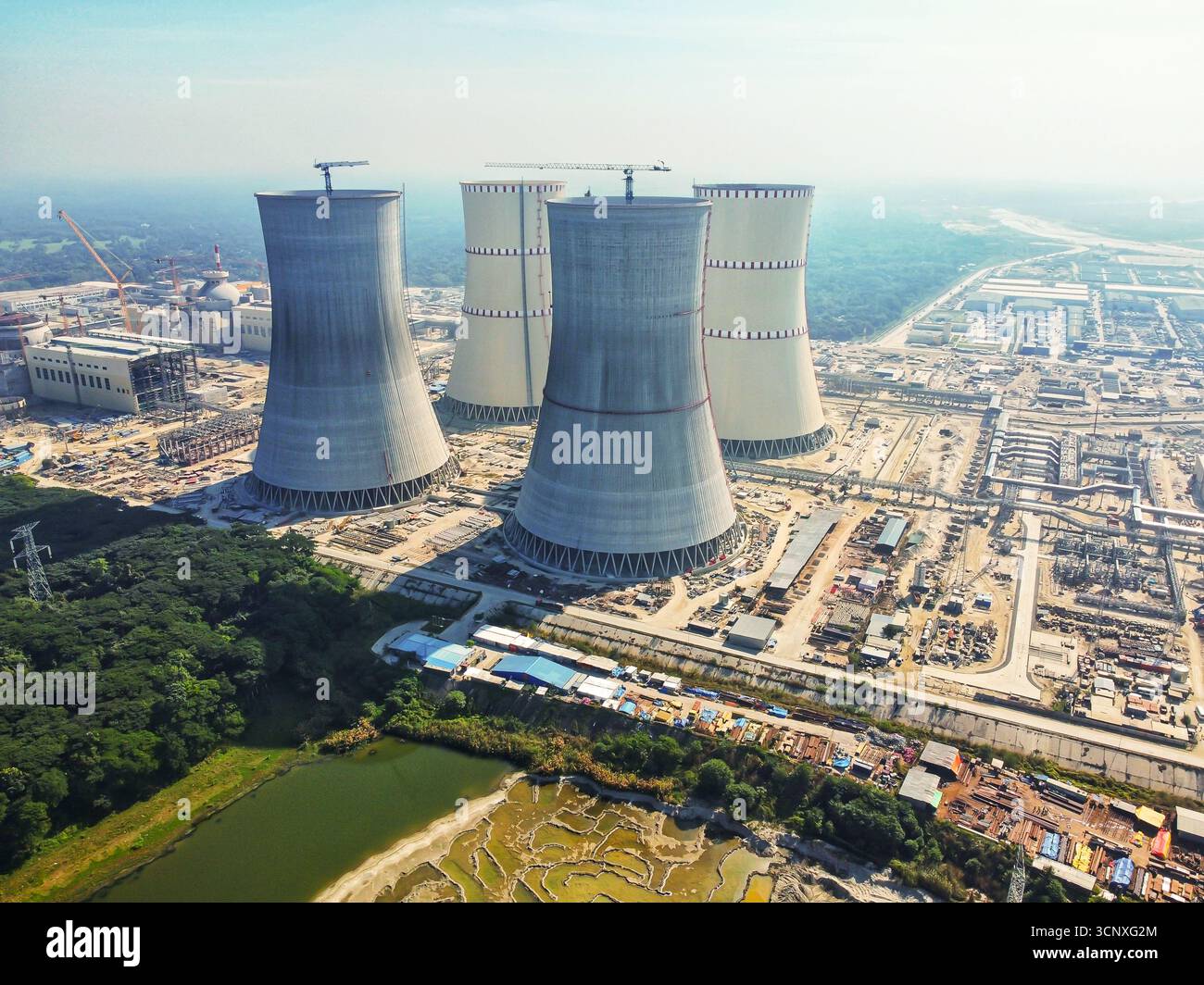 Aerial view of colossal cooling towers pierce the horizon, juxtaposed ...