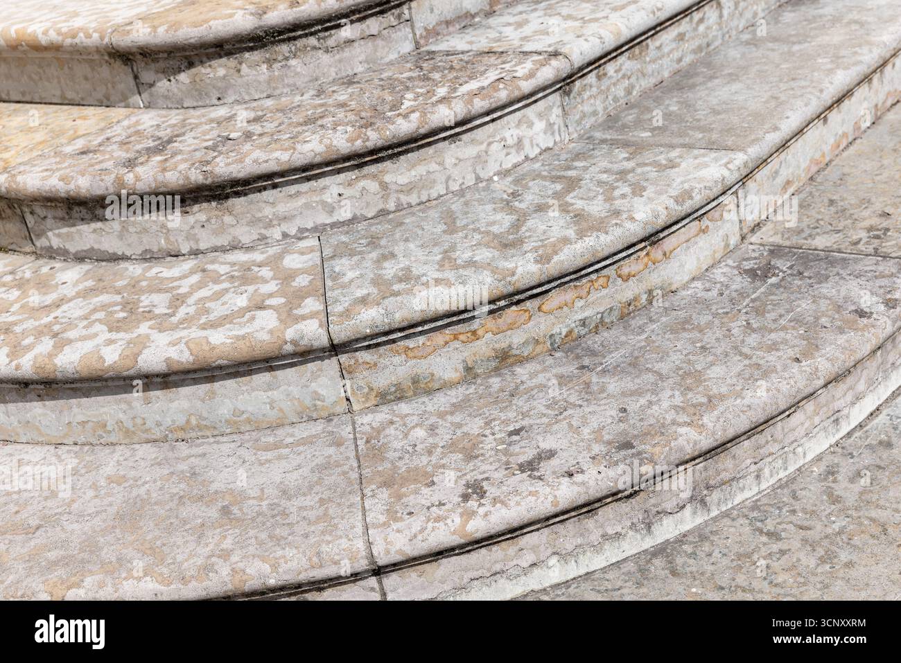 Close-up view of worn marble stairs with curved edges, showing natural ...