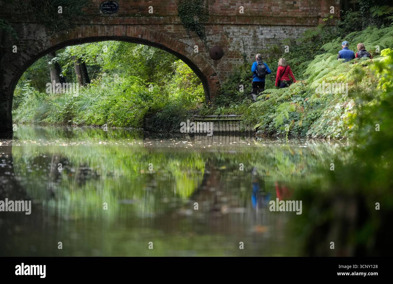 People walk along the Basingstoke Canal near to Dogmersfield in ...