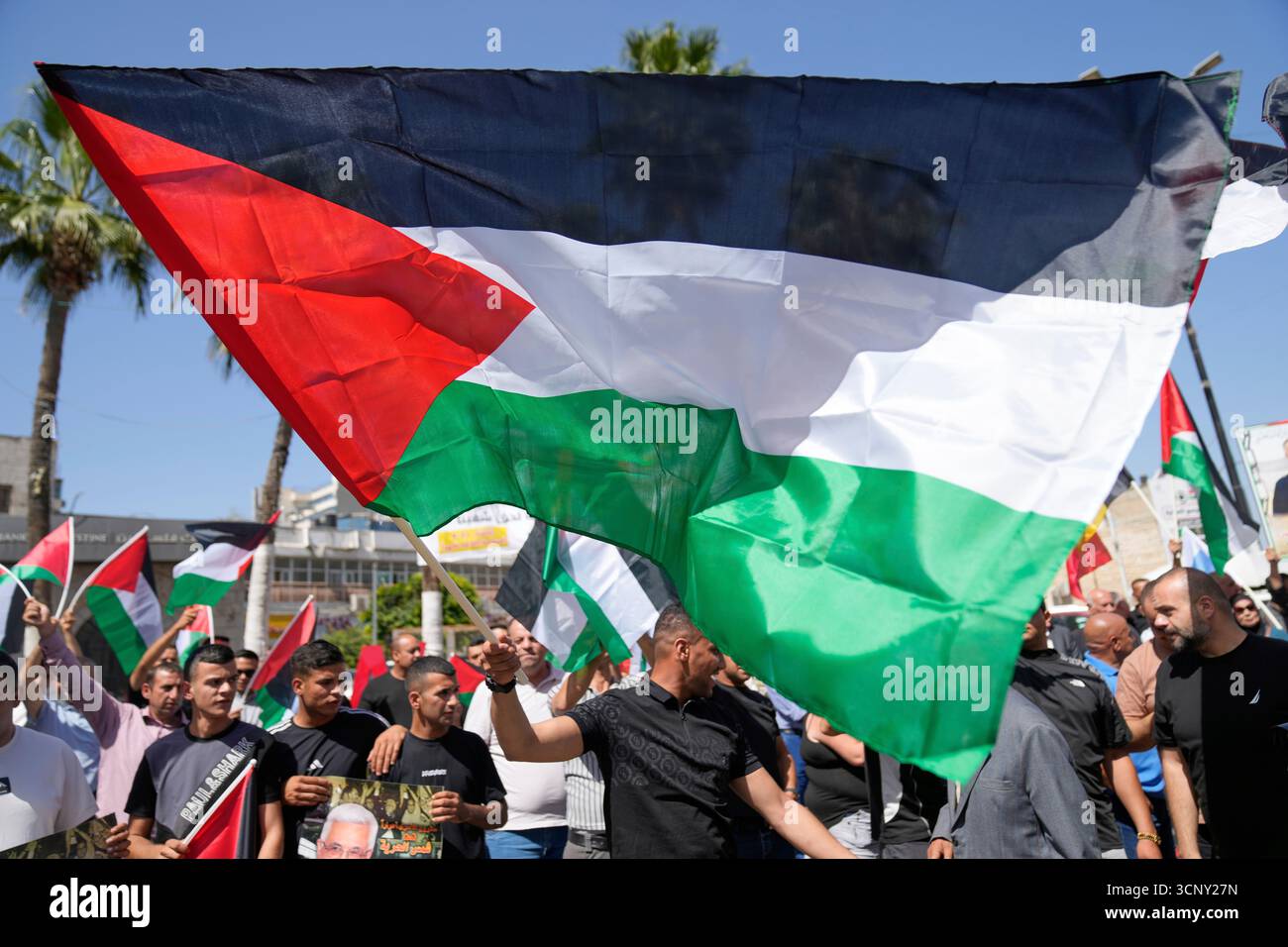 Palestinians fly their flags during a rally in support for Gaza and ...