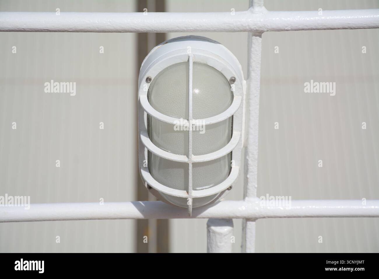Close up of a marine bulkhead light fixture, with a protective grid ...