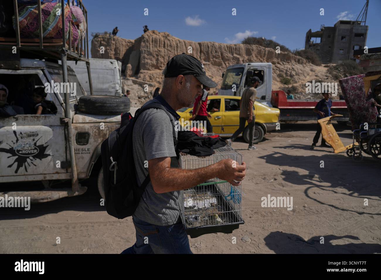 Mohammed Al-Muqayyad flees northern Gaza Strip, carrying his birds in a ...