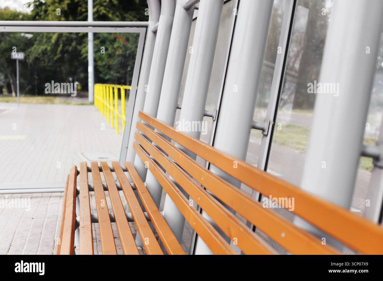 Wooden bench at bus stop. Modern covered public transport station with ...
