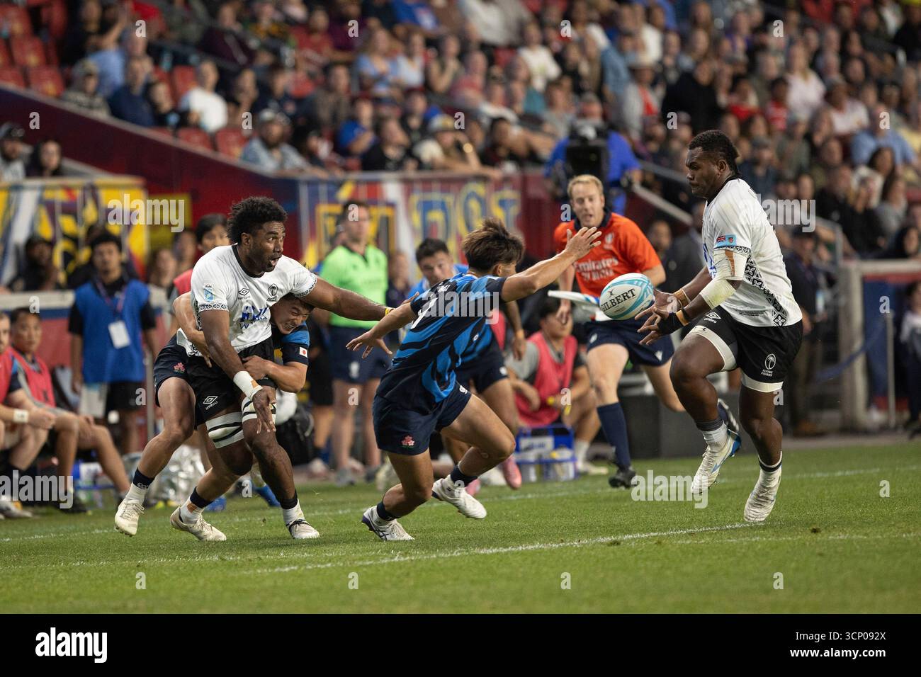 Fiji's Etonia Waqa passes the ball to Inia Tabuavou against Japan's ...