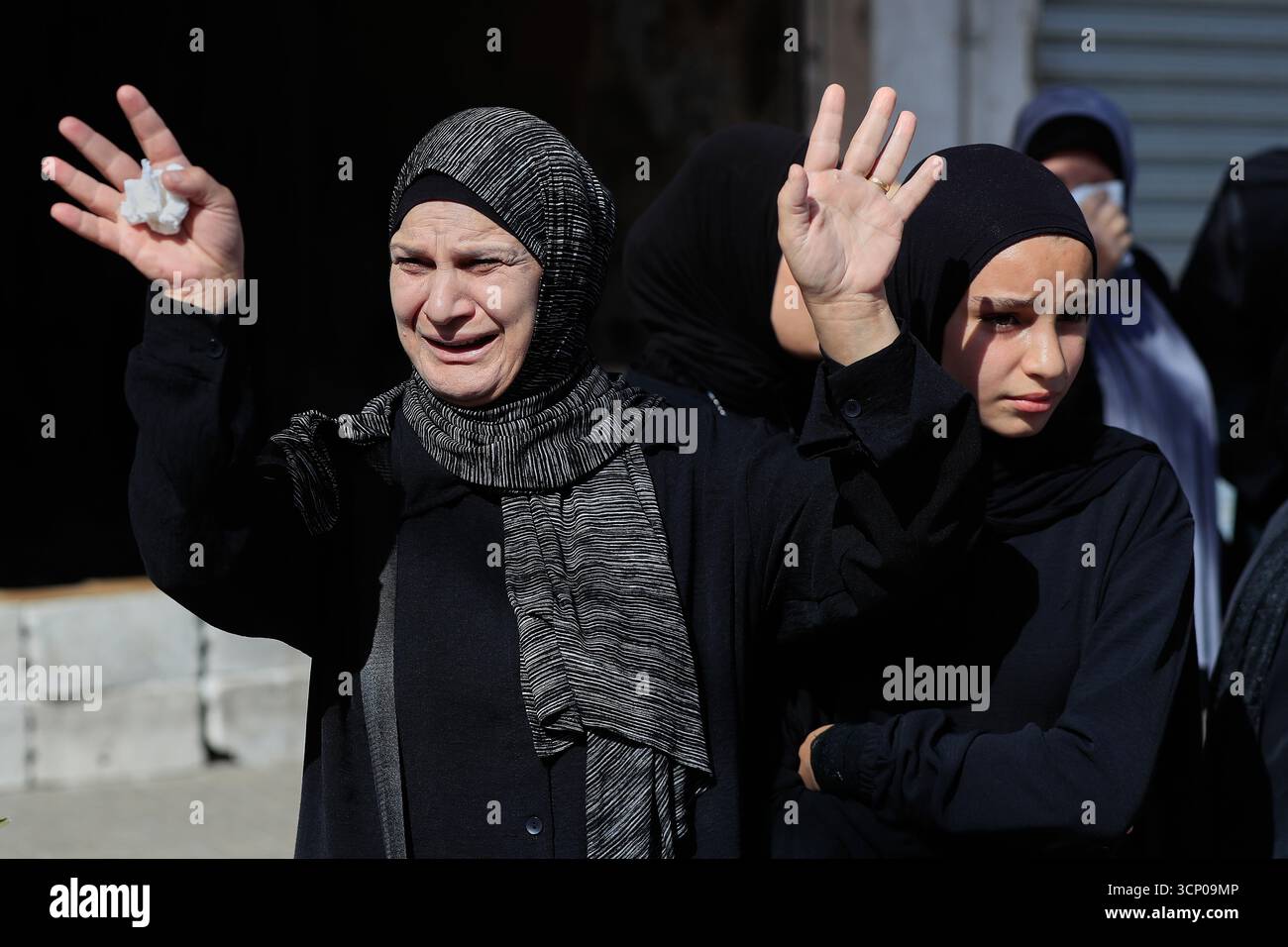 A woman mourns during the funeral of Shadi Charara and three of his ...