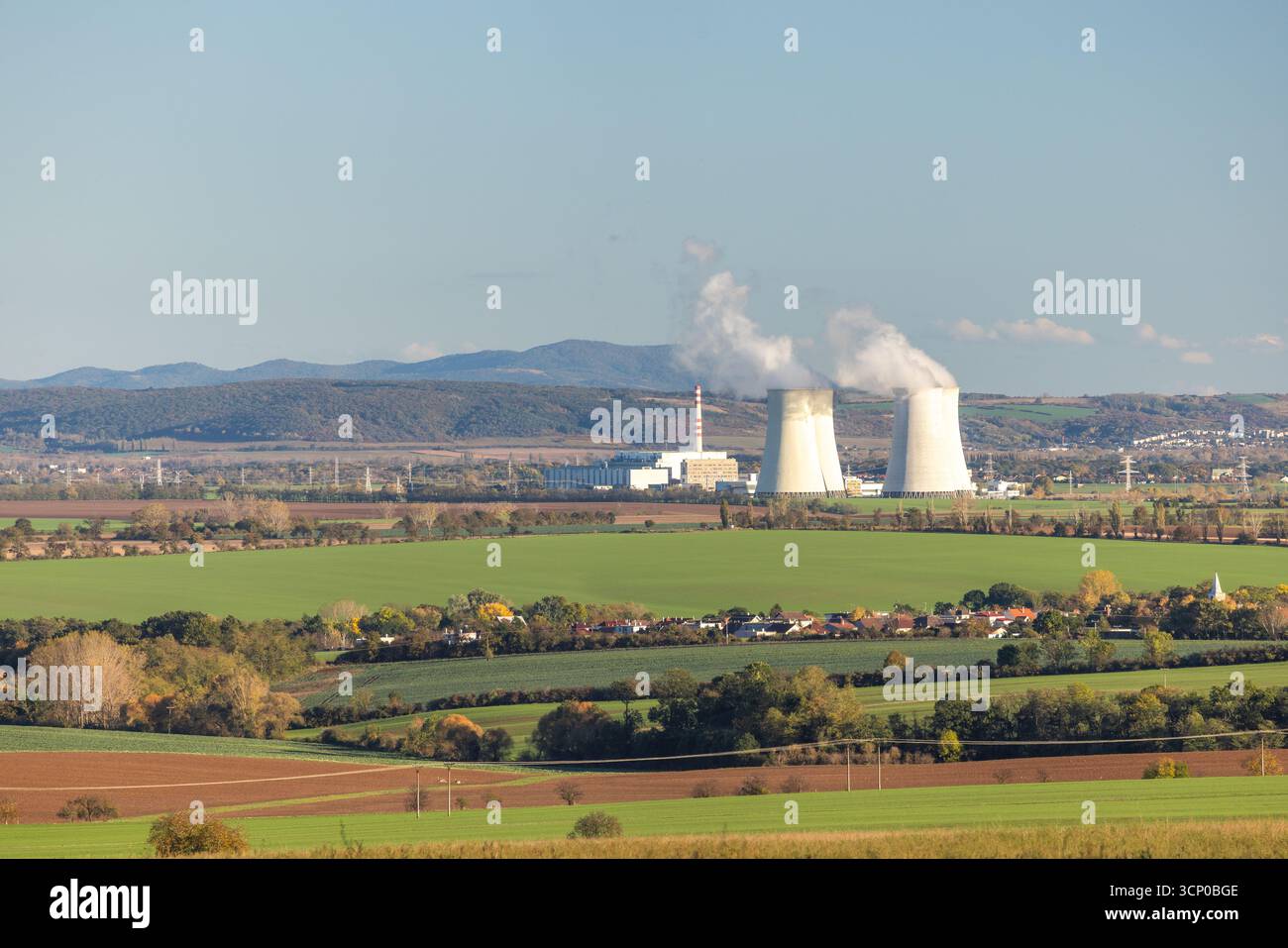 Nuclear power station nestled in landscape with rolling hills and ...