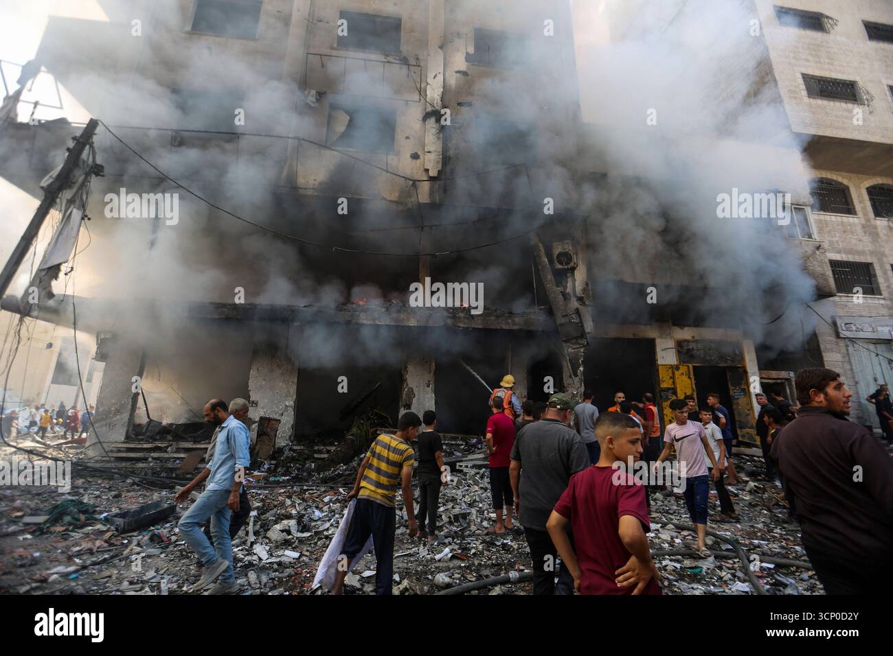Palestinian firefighters trie to extinguish fire at a residential ...