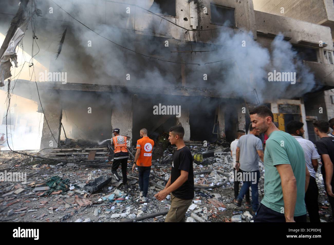 Palestinian firefighters try to extinguish a fire at a residential ...