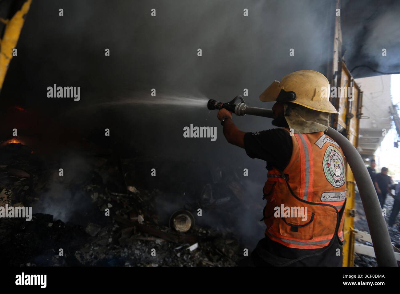 Palestinian firefighters try to extinguish a fire at a residential ...
