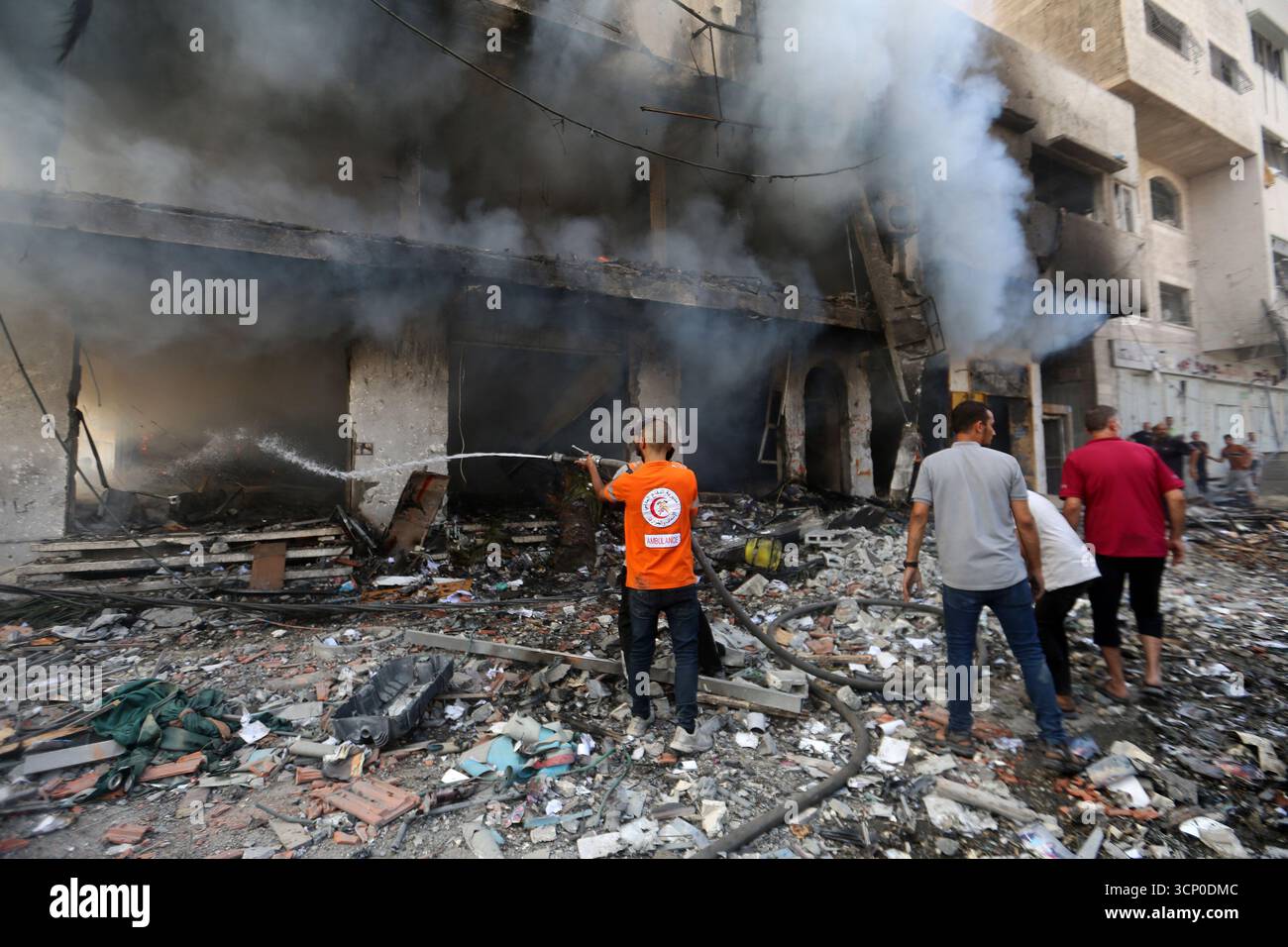 Palestinian firefighters try to extinguish a fire at a residential ...