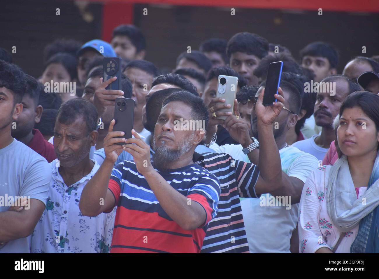 People watch a live broadcast of Zubeen Garg's funeral in Nagaon ...