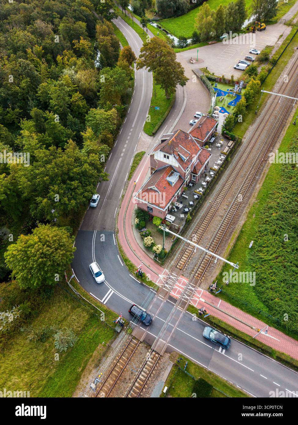 Aerial view of a diagonal railway crossing in a semi rural area, with ...