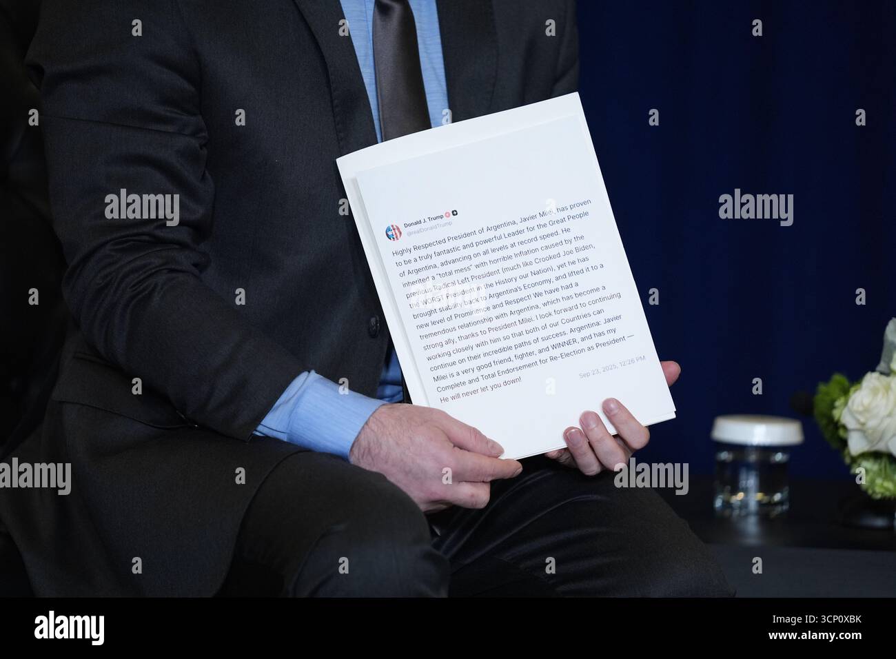 Argentine President Javier Milei holds a paper handed to him by ...