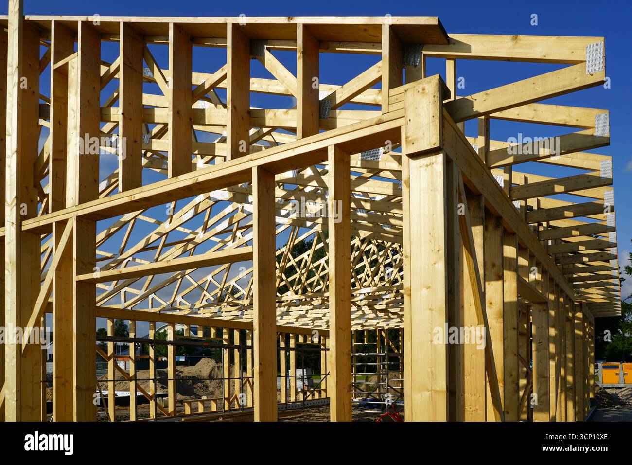 Wooden house frame with beams and roof trusses under construction ...