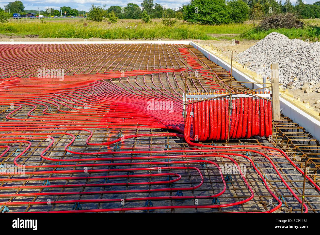 Red underfloor heating pipes laid in a reinforced concrete foundation ...