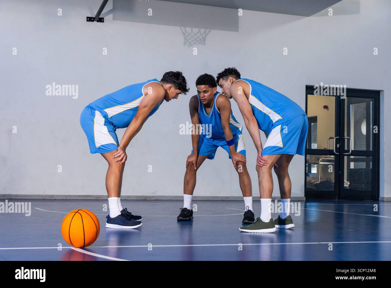 African american male basketball players huddling on court with ...