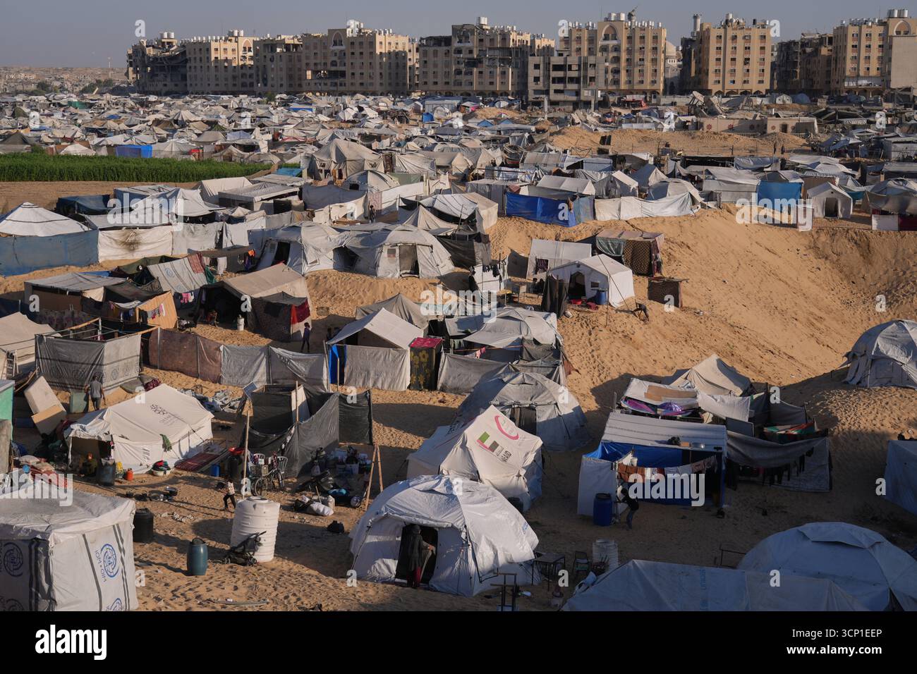 A Palestinian woman enters her tent in a camp for displaced people in ...