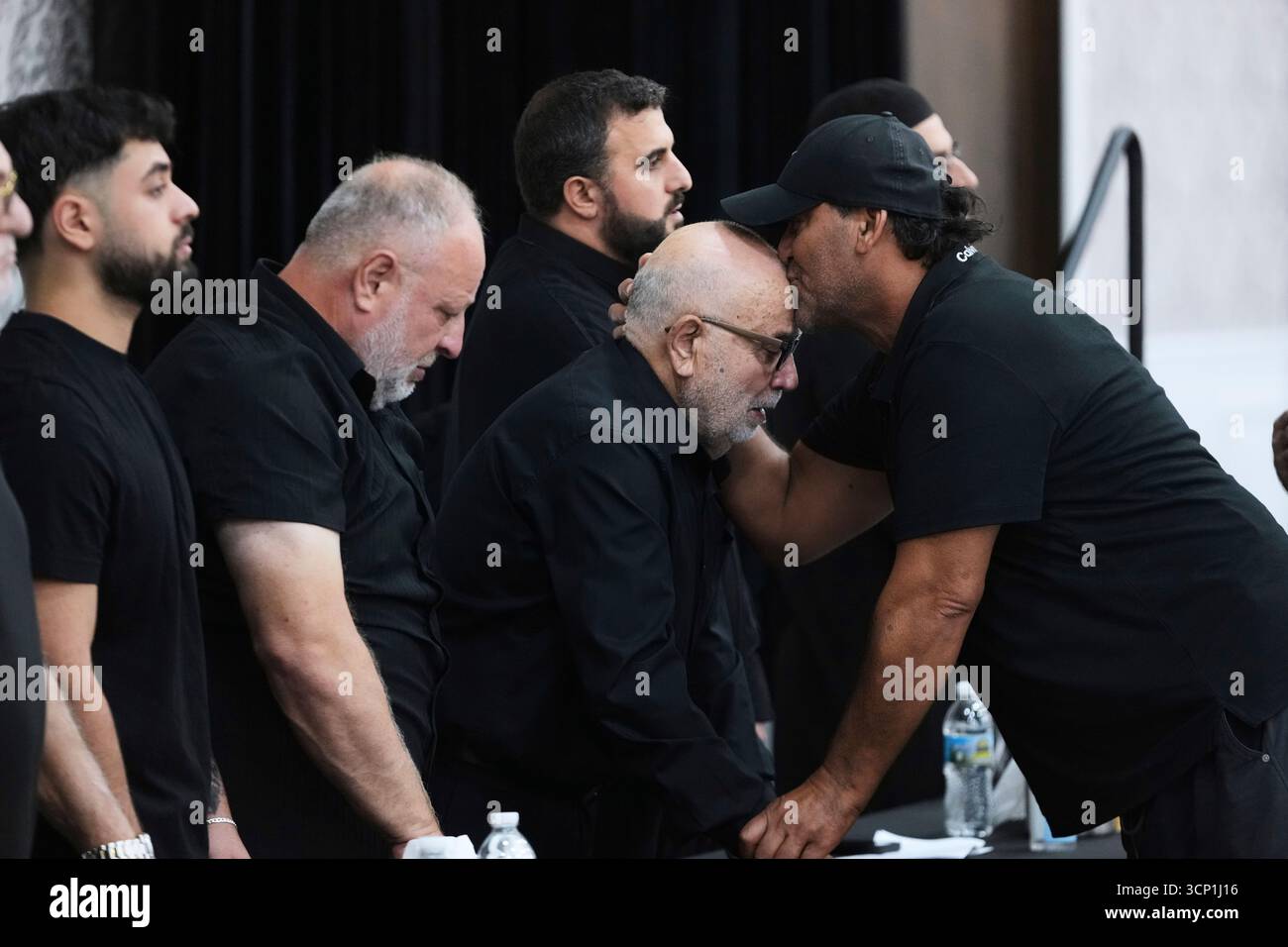 A mourner, right, kisses Hajj Sobhi Charara, second right, as Hajj ...