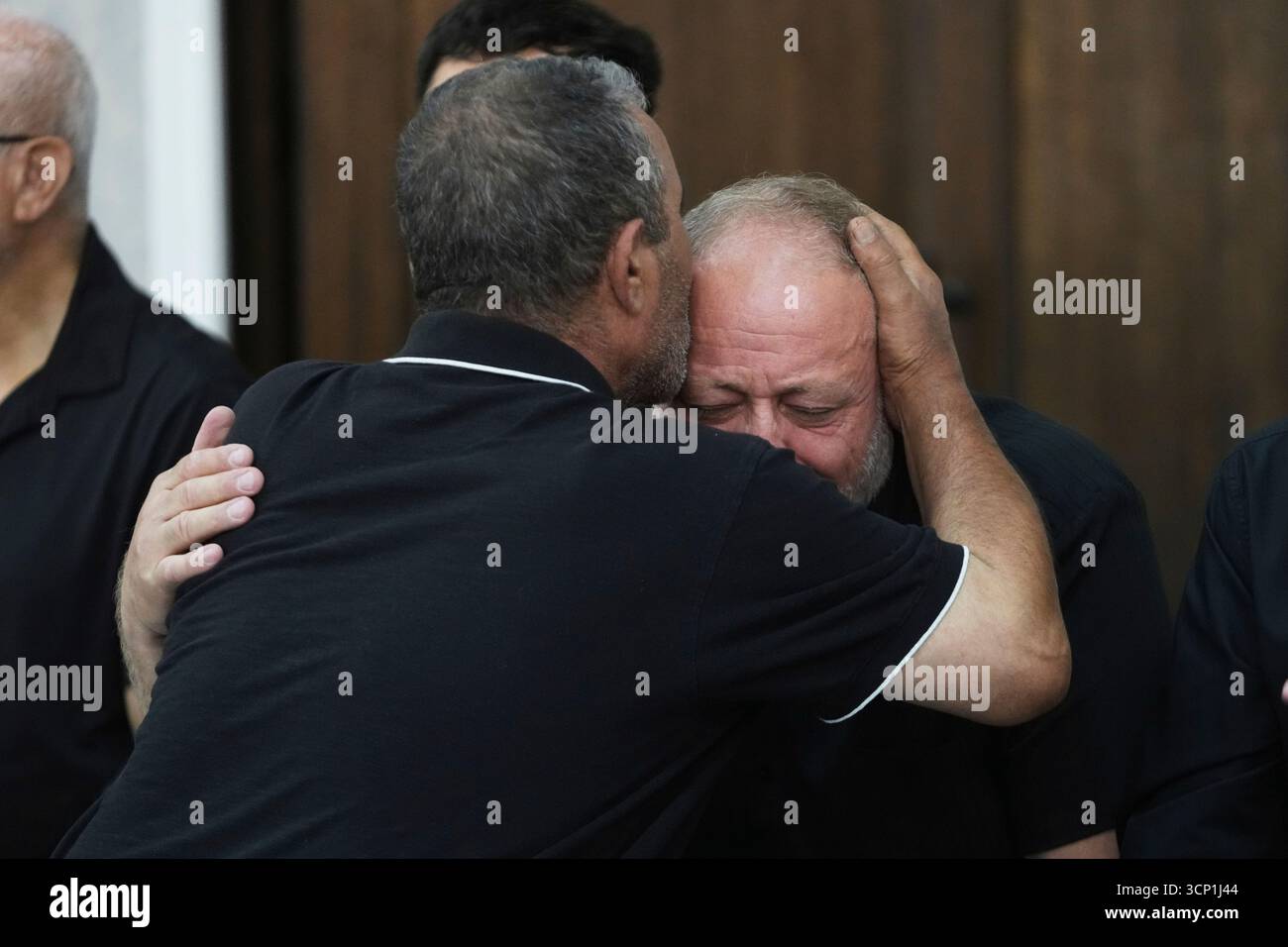 A mourner kisses Hajj Nidal for those, including three children, killed ...