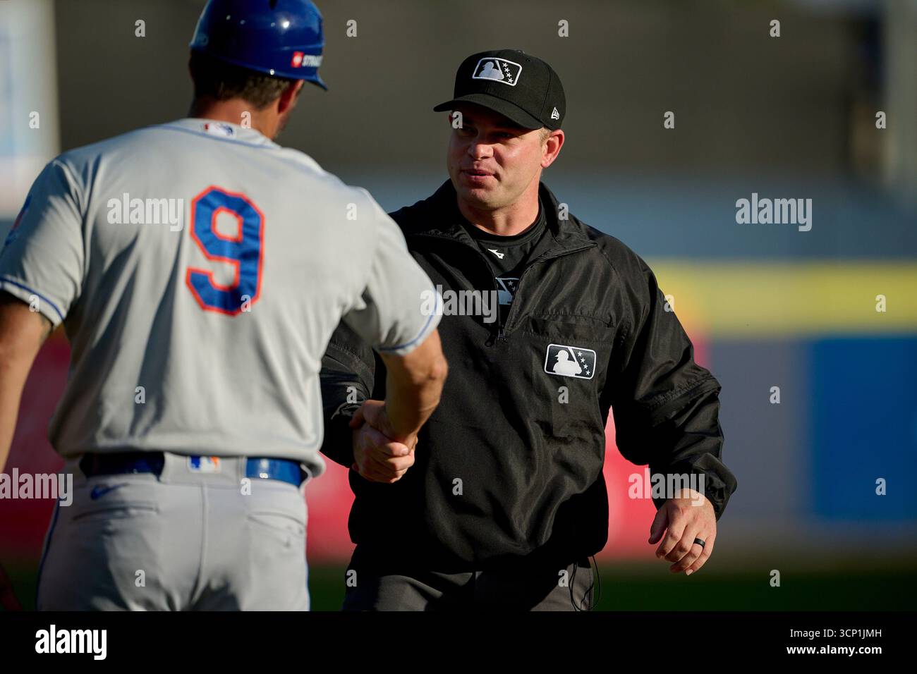 Syracuse Mets coach J.P. Arencibia (9) greets umpire Denver Dangerfield ...